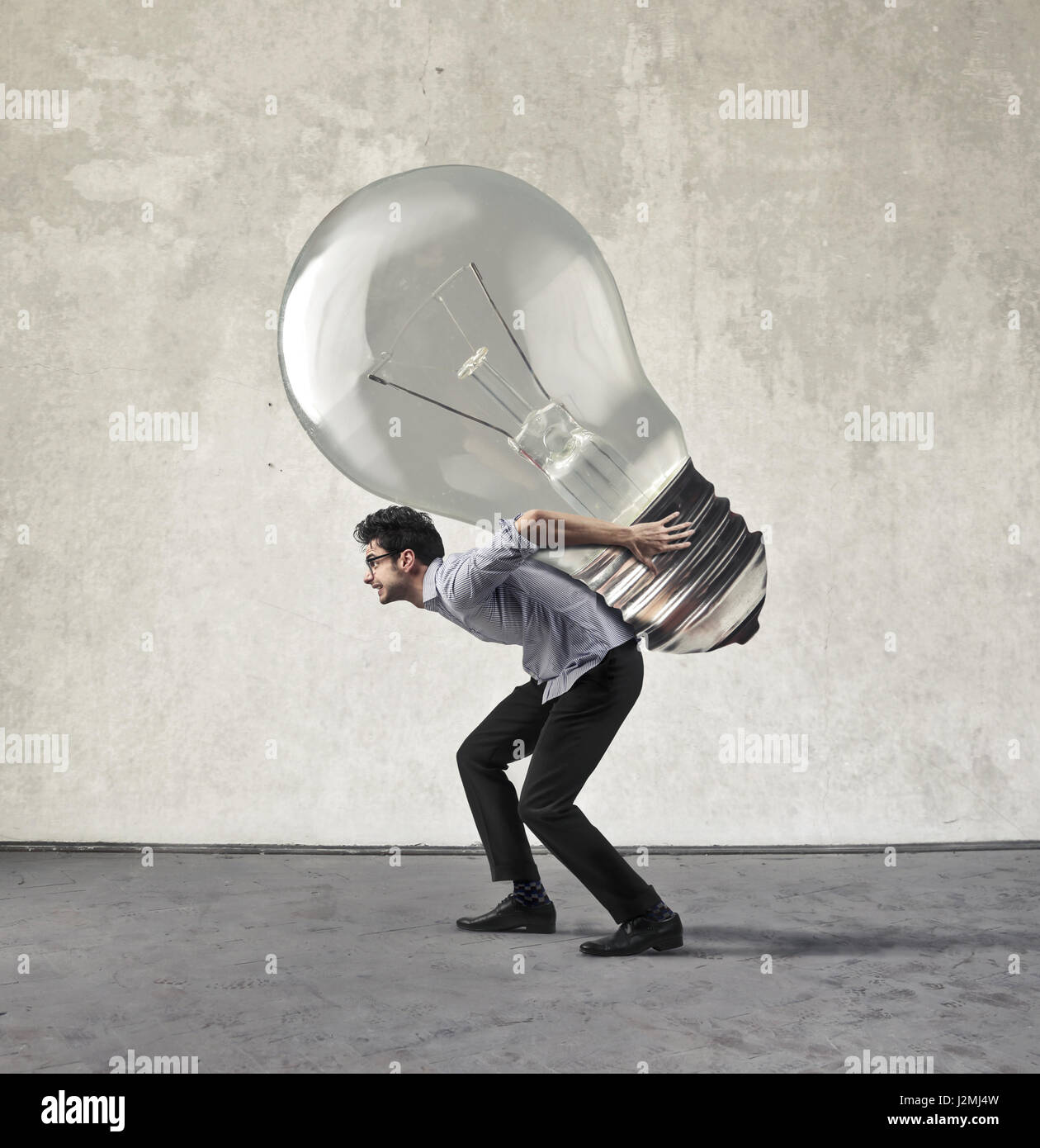 Tired businessman carrying light bulb hi-res stock photography and ...