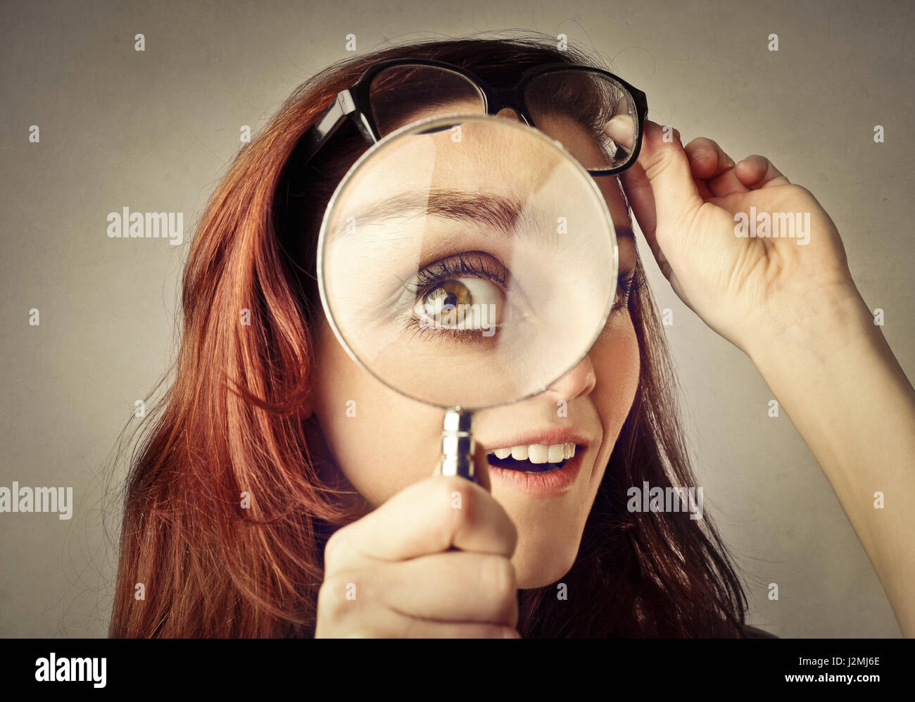 Brunette woman with magnifying glass Stock Photo - Alamy
