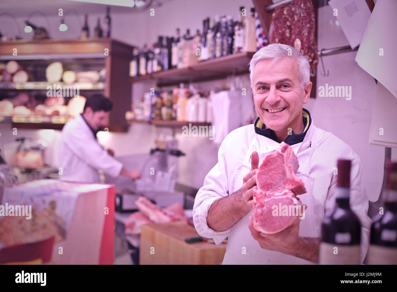 Butcher man holding meat Stock Photo - Alamy