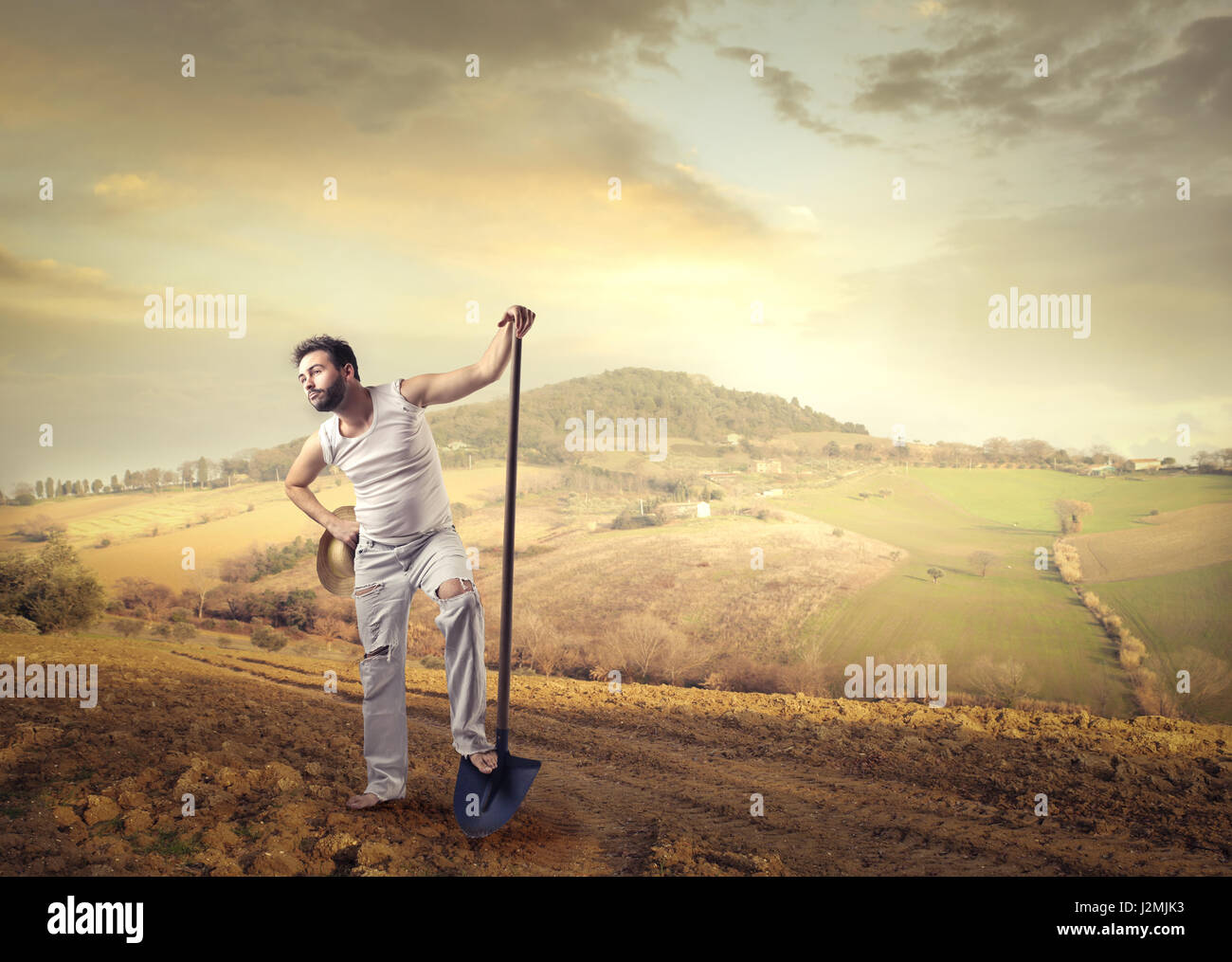 Tired worker on field Stock Photo - Alamy