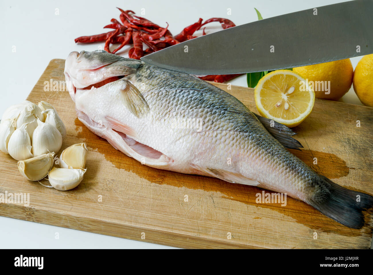 Cutting the fish for Seabass steam with lemon, garlic and chili - Thai ...