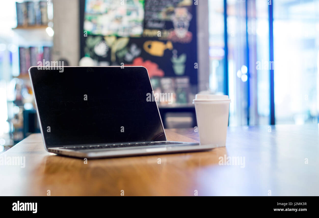 select focus on blank screen monitor notebook on wood table in cafe for ...