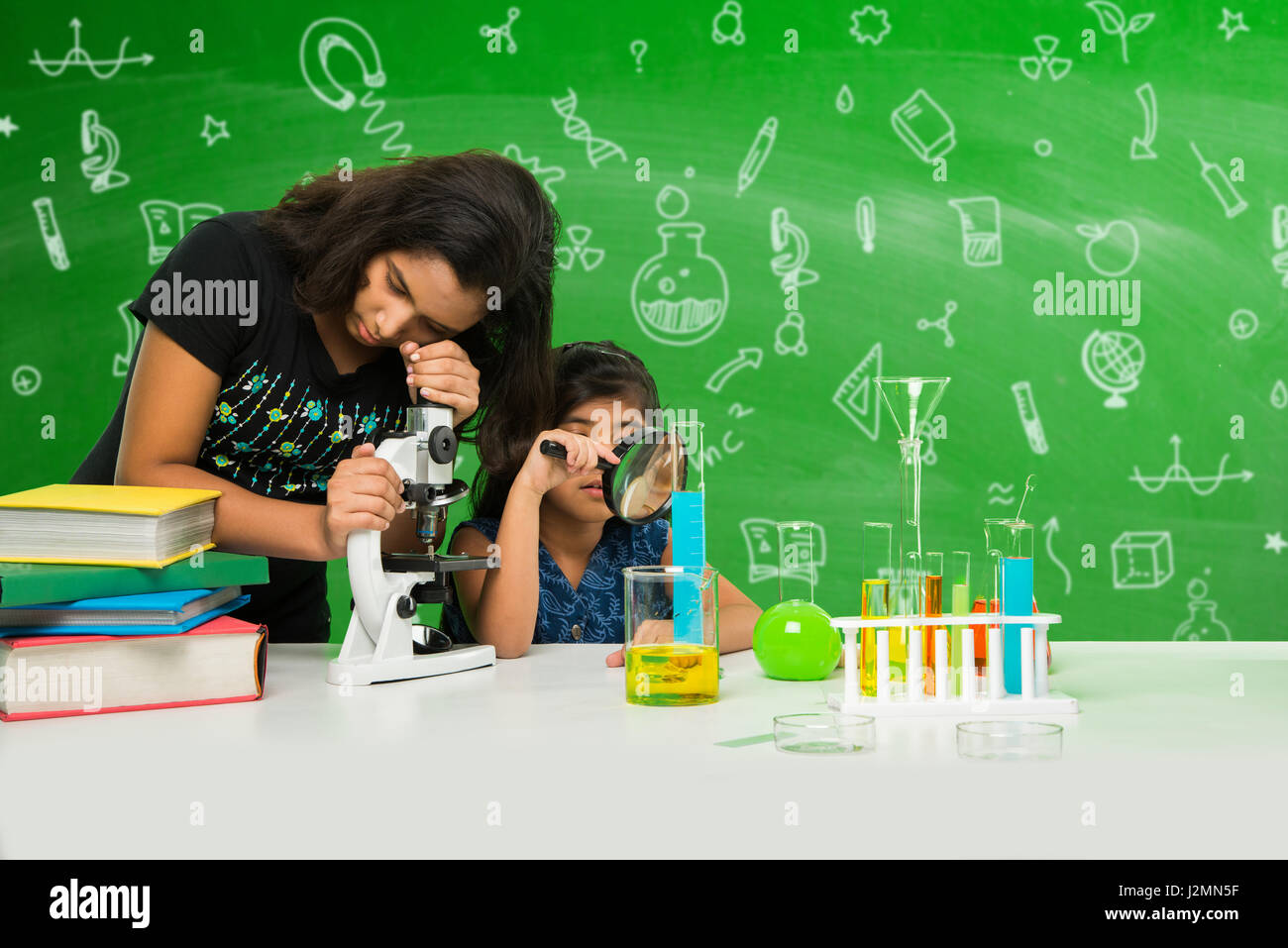 cute indian kids doing science experiment in chemistry lab or biology ...