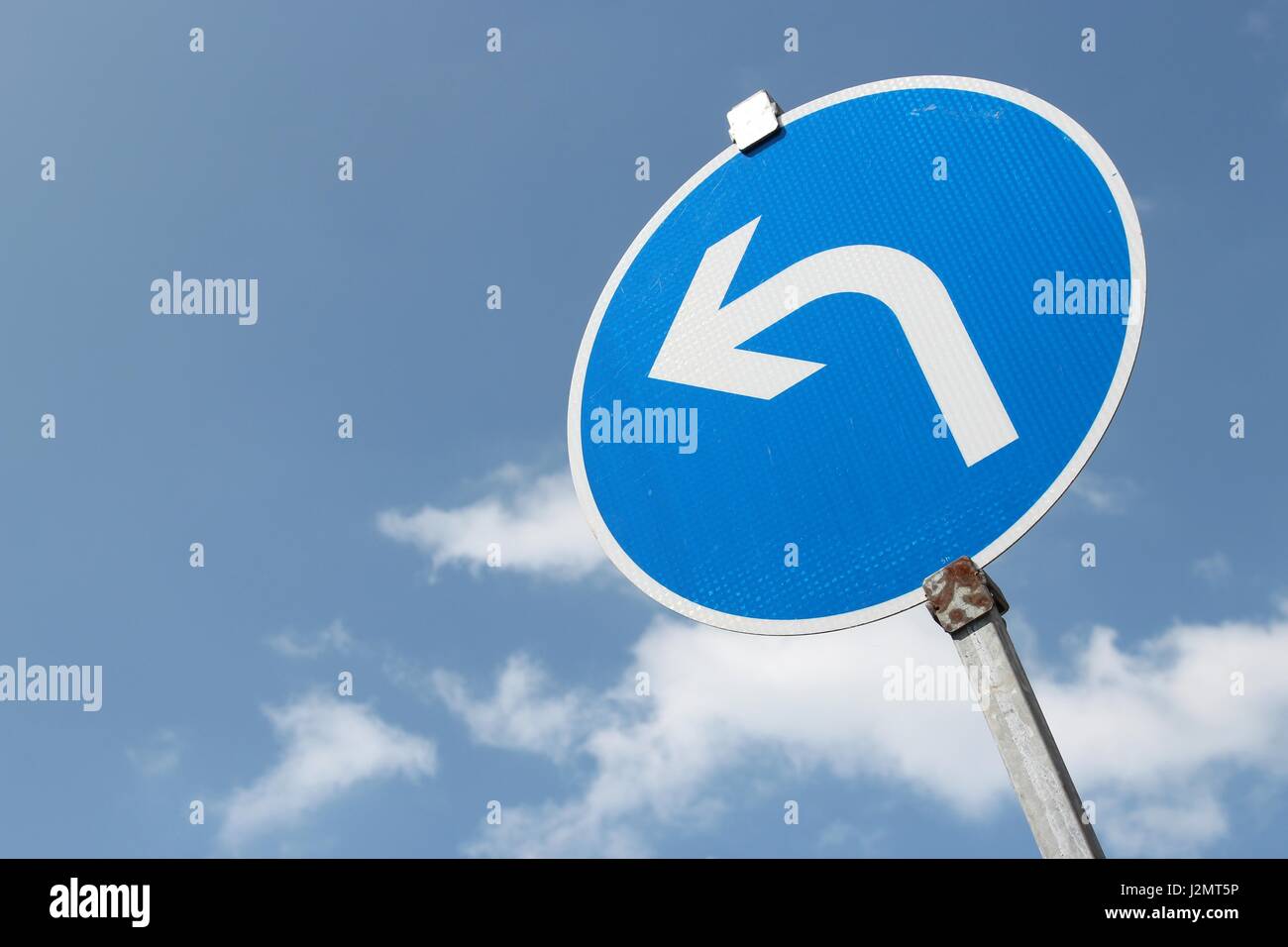 German road sign: left turn Stock Photo - Alamy