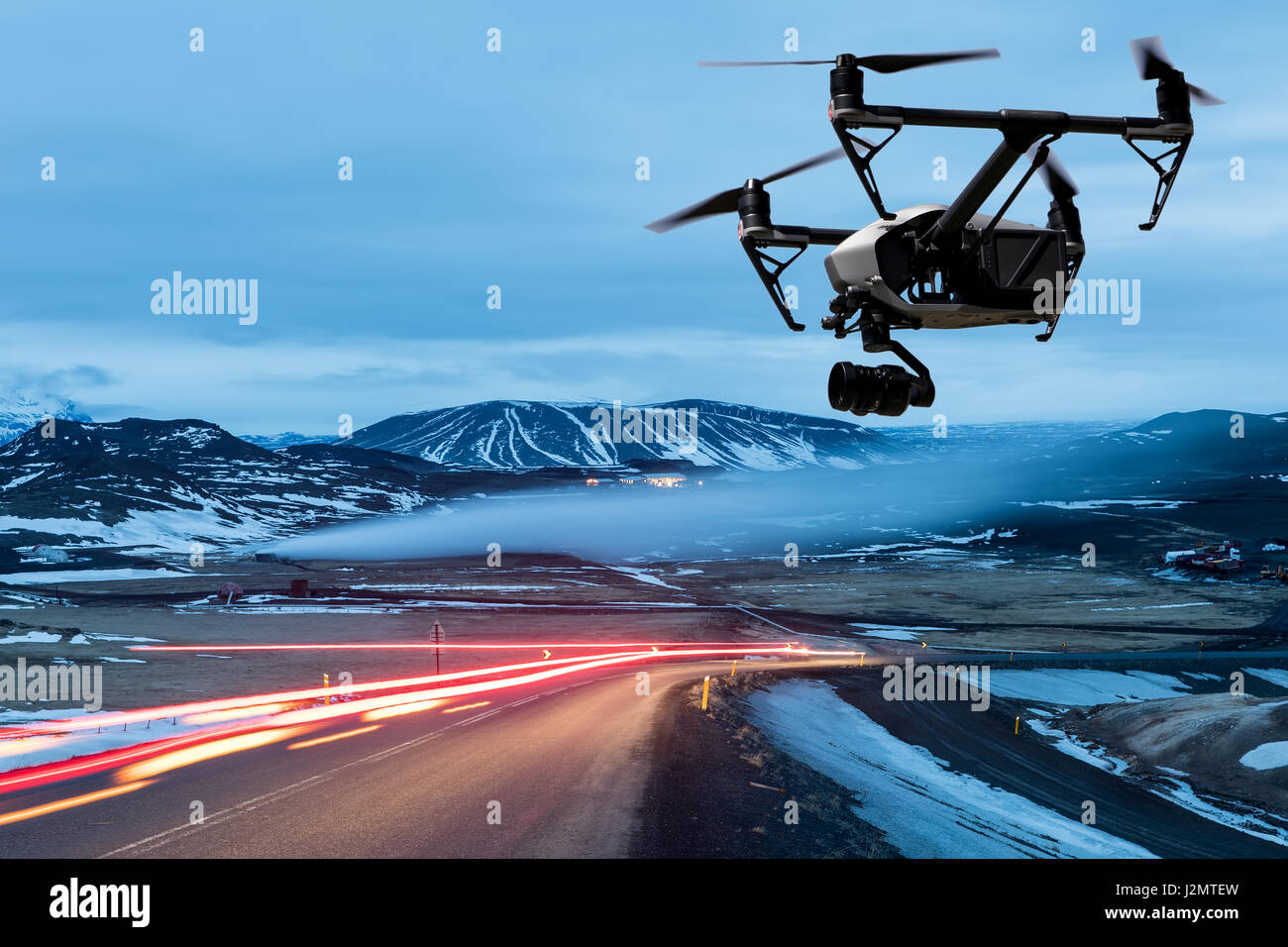 drone quad copter with a camera flies over a road with car lights Stock ...