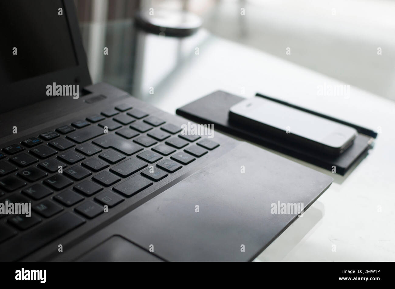laptop with smart phone on glass table Stock Photo - Alamy