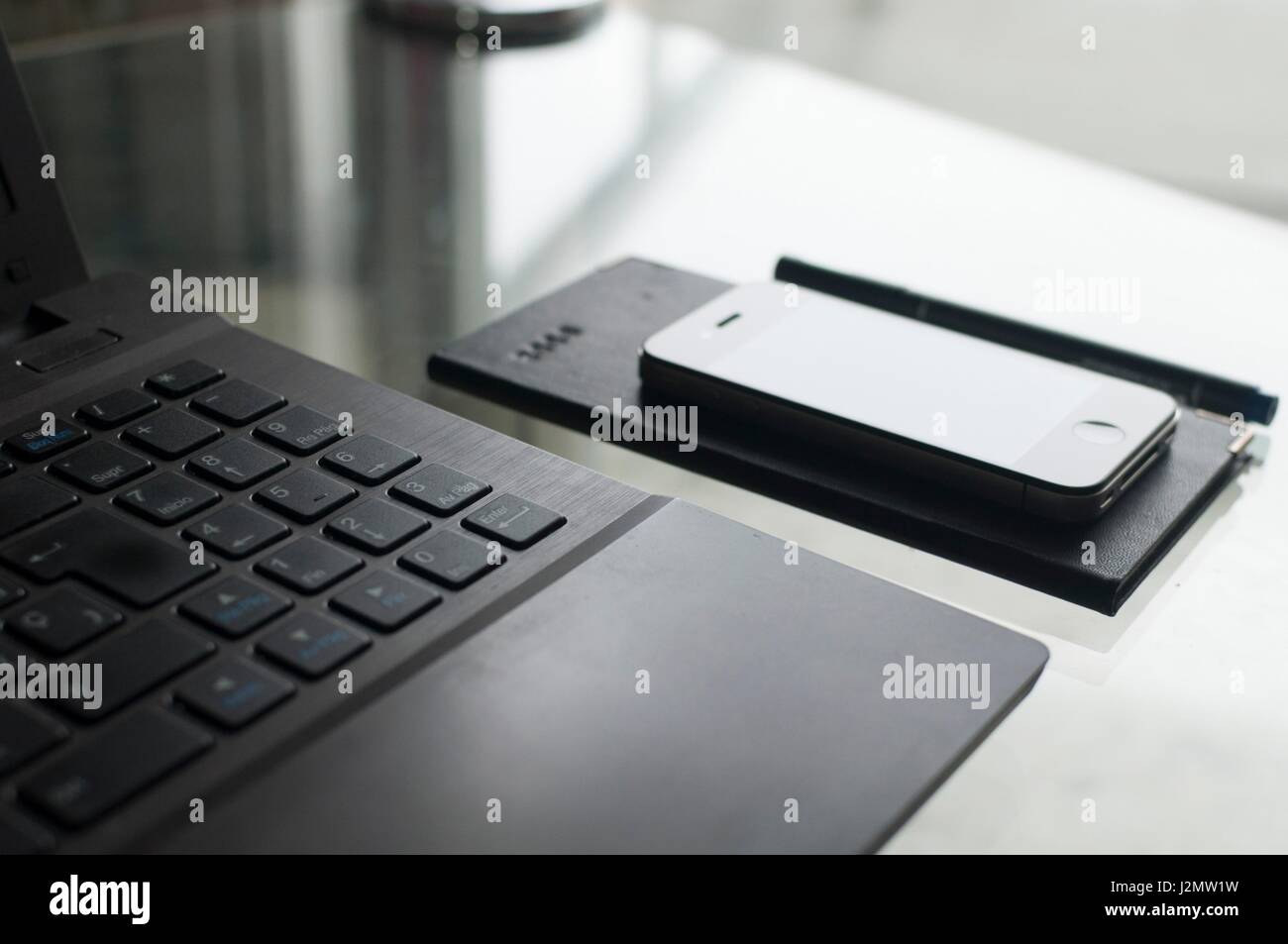 laptop with smart phone on glass table Stock Photo - Alamy