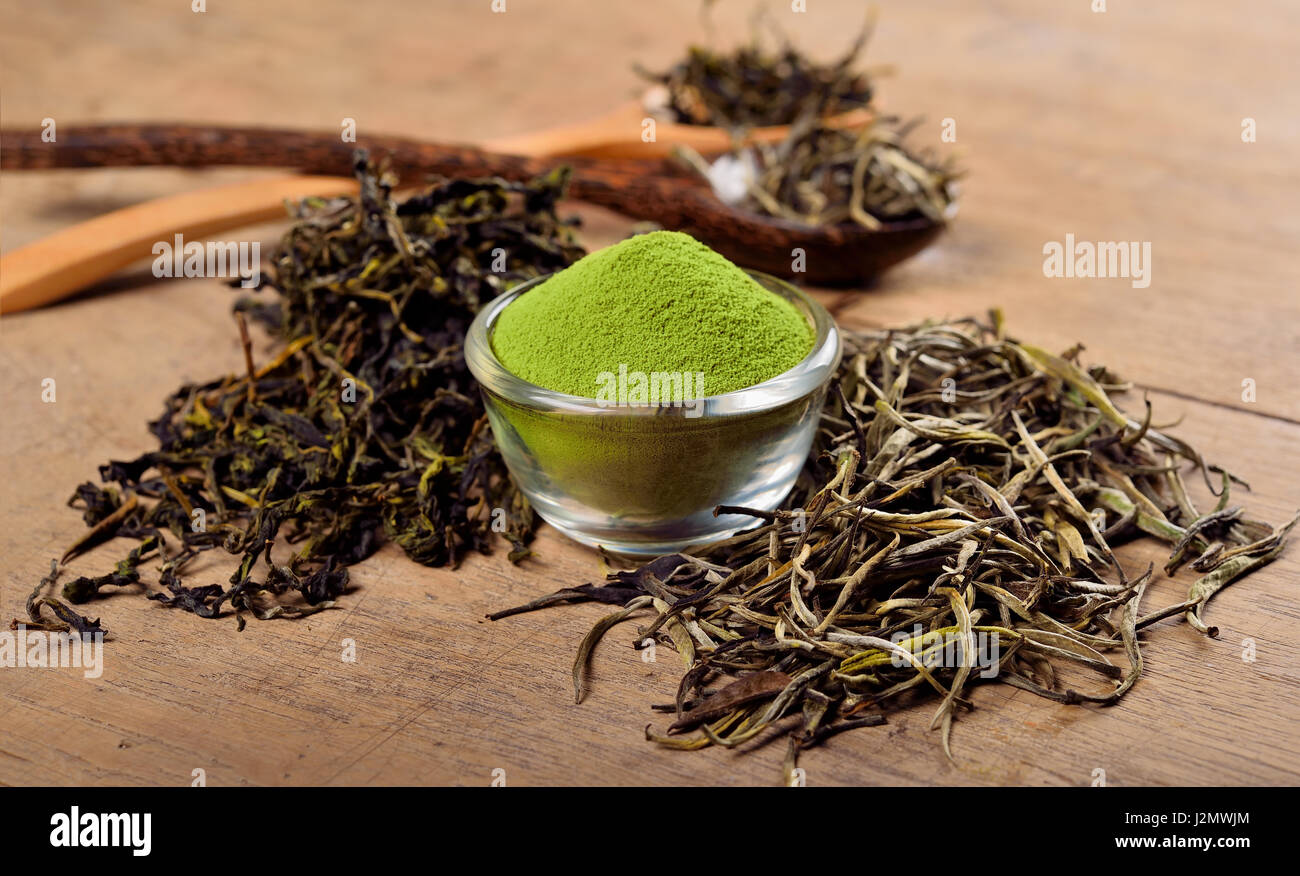 Dried tea leaf and powder with spoon on wood Stock Photo - Alamy