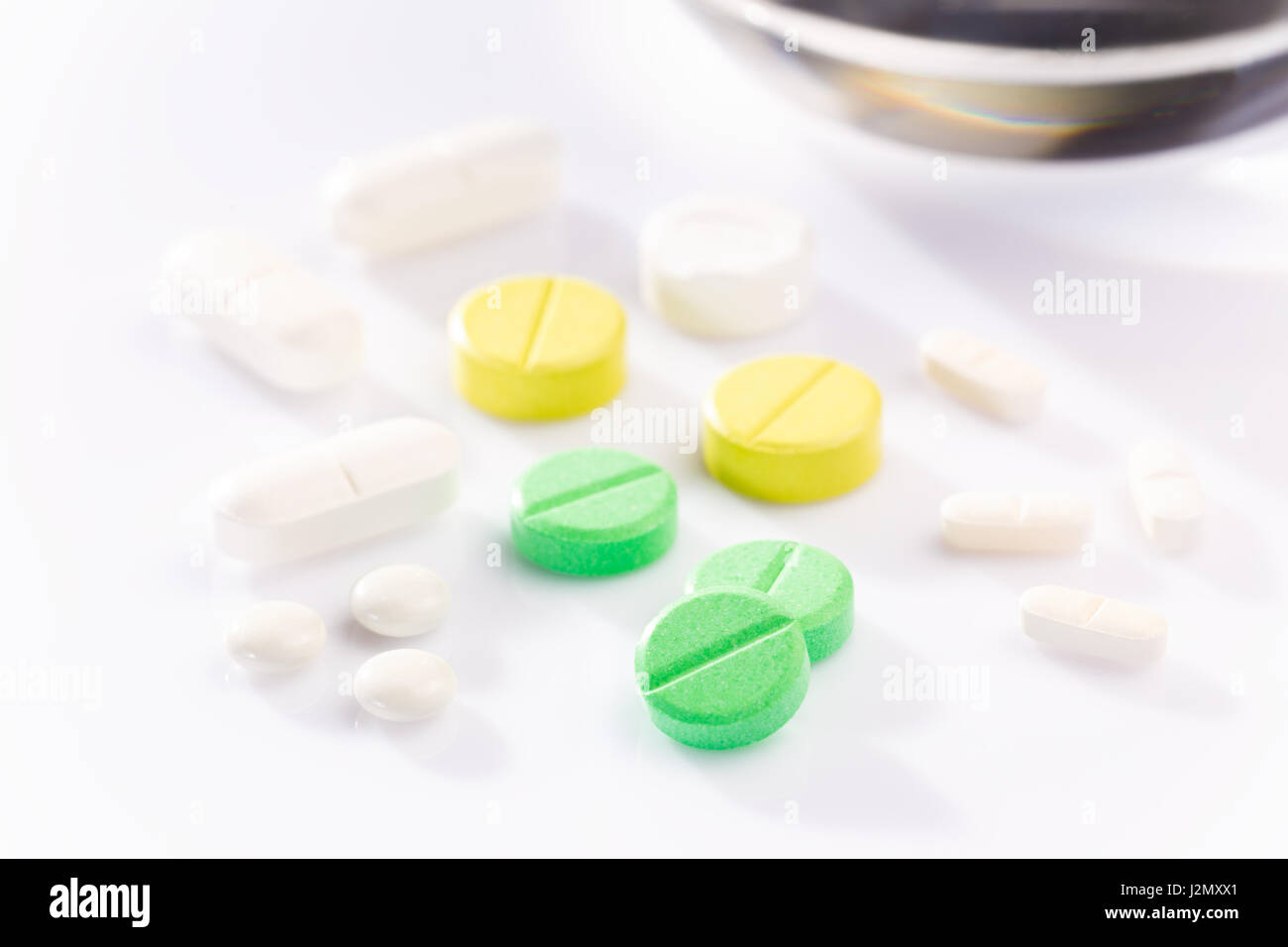 Medicine pills in various shapes, colors, and sizes on white background ...