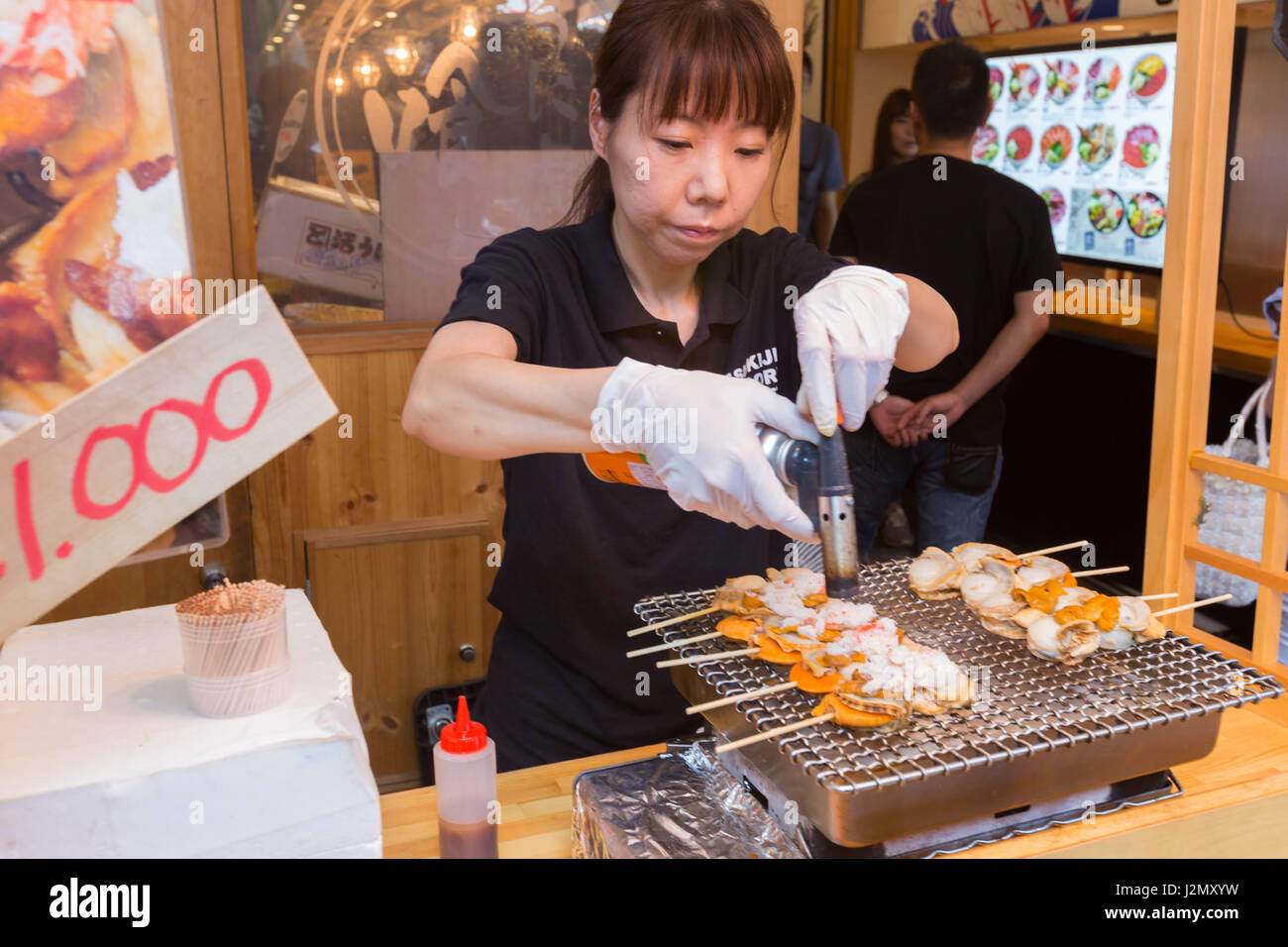 TOKYO, JAPAN - 18 JULY 2016 - Street vendor man cooks seafood at ...