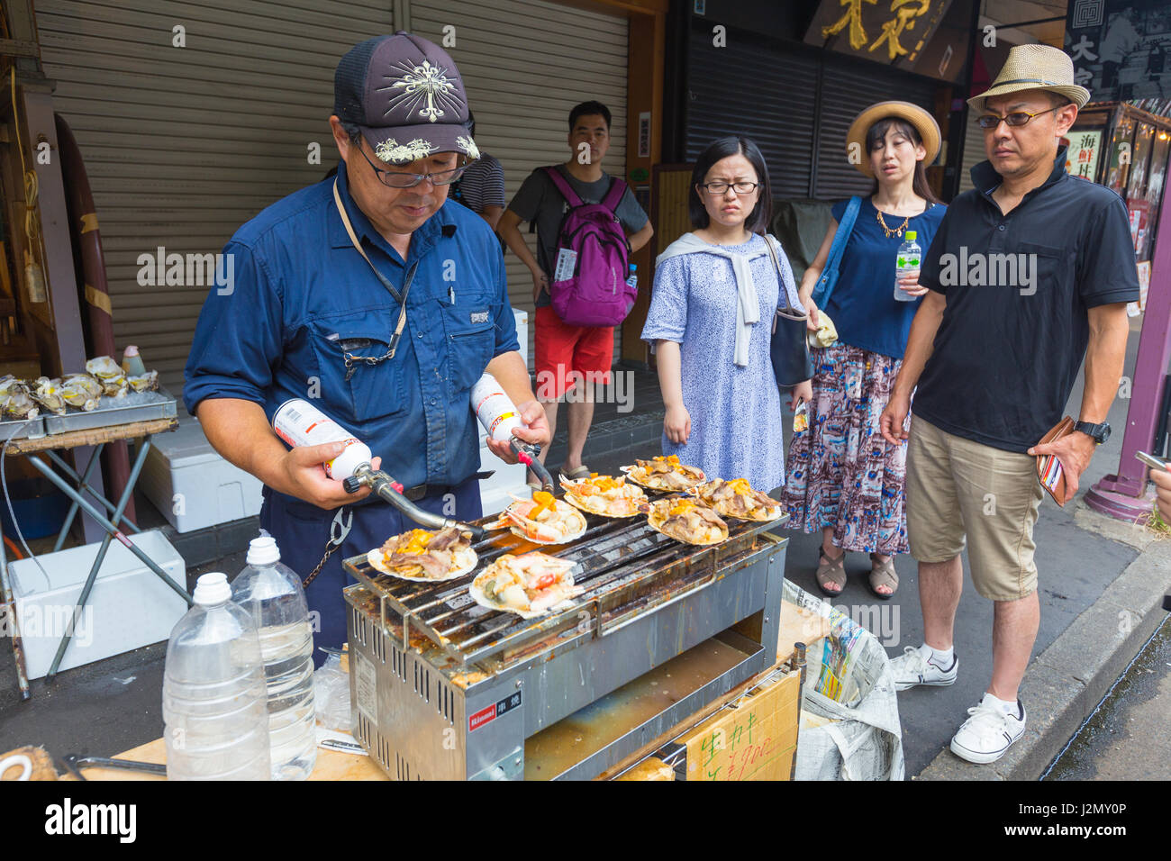 TOKYO, JAPAN - 18 JULY 2016 - Jananese man street vendor cooks seafood ...
