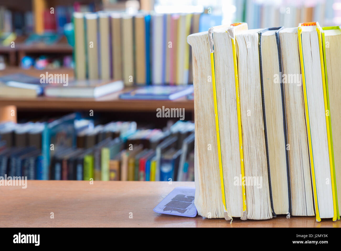 Hard covered library books line up on a shelf, selective focus with ...