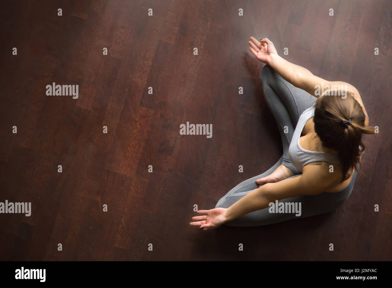 Young yogi woman practicing yoga, sitting in Half Lotus exercise, Ardha ...