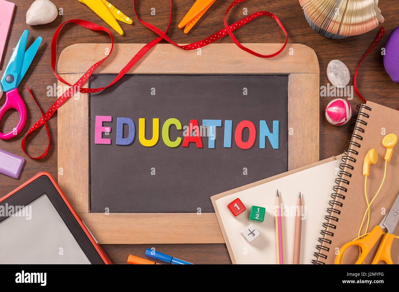 Education word formed by color wooden alphabets on small blackboard ...