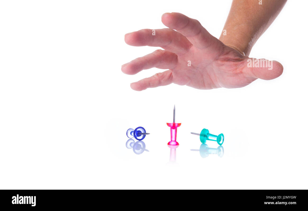 Male hand reaching out for color plastic sharp pins on white background ...