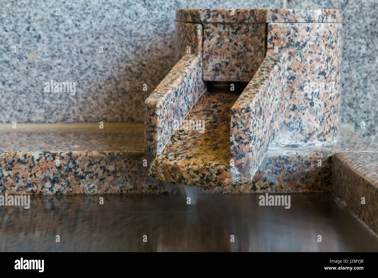 Close up section of onsen marble bathtub and marble faucet, Japanese ...
