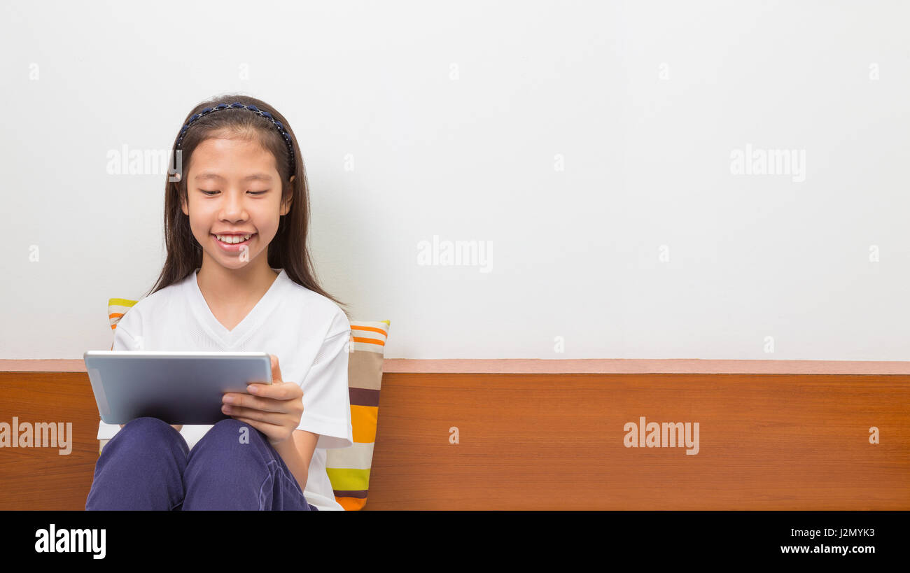 Happy smiling asian girl sitting using computer tablet, room for copy ...