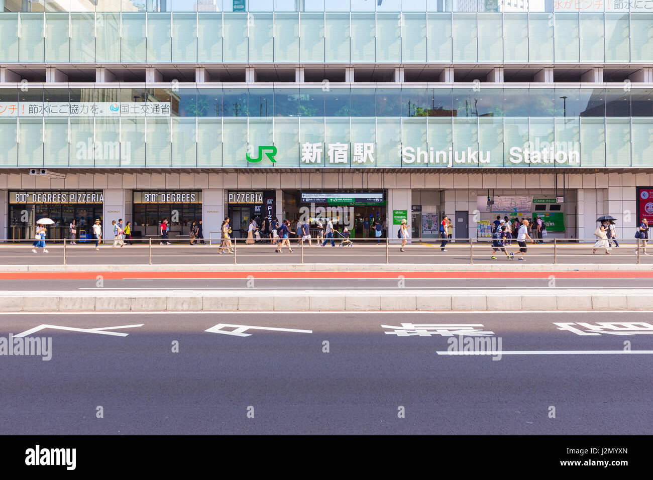 TOKYO, JAPAN - 17 JULY 2016 - Pedestrians walk about along empty street ...