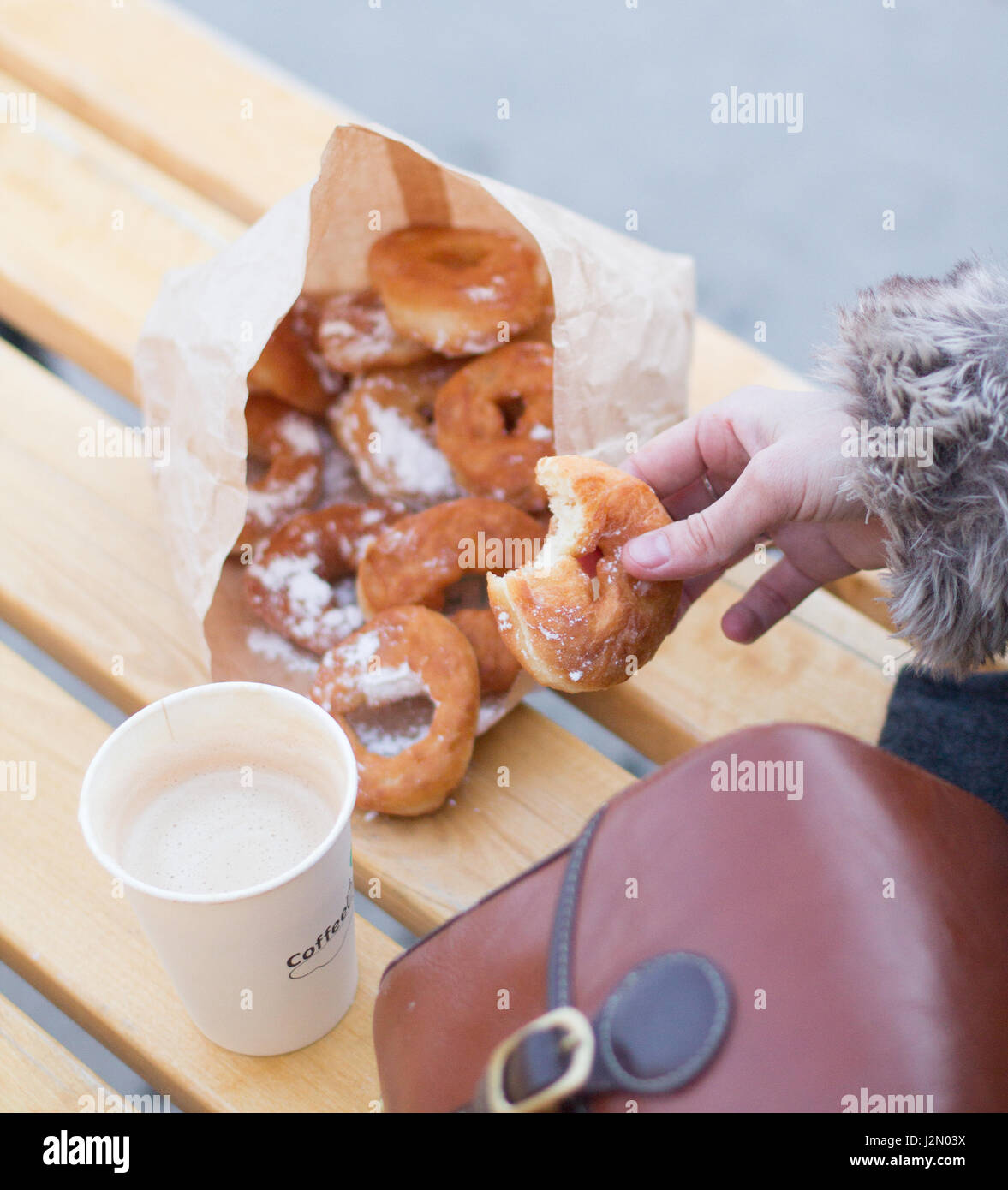 Fast food. Sugar donuts in the hands of the girl. Food on the street ...