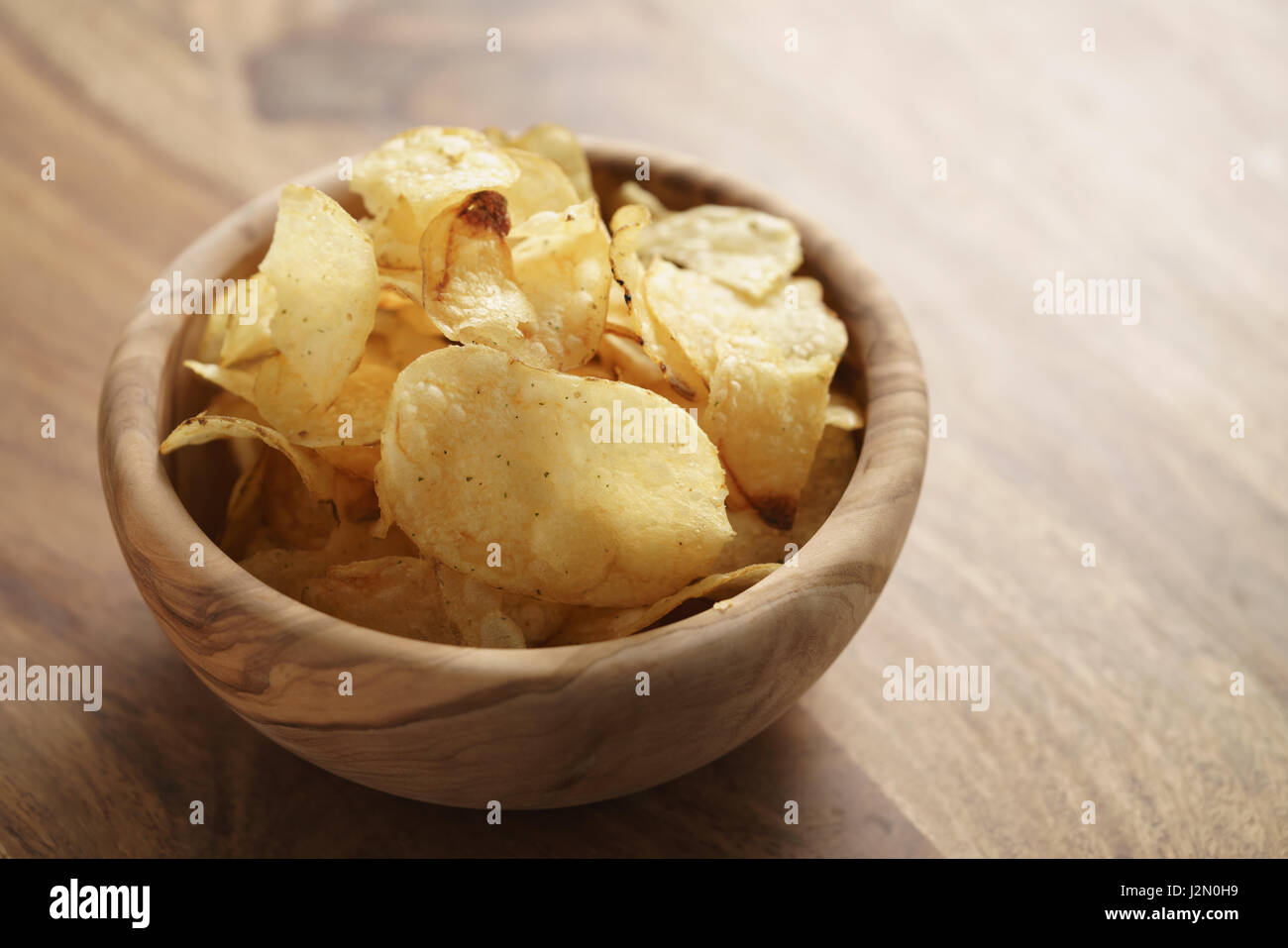 potato chips with herbs in wood bowl on rustic table Stock Photo - Alamy