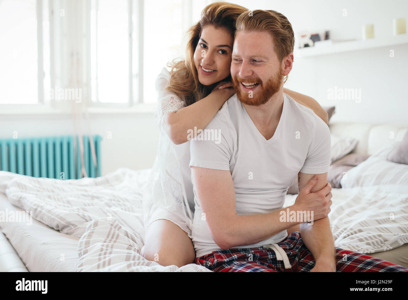 Beautiful happy and romantic couple waking up smiling in bedroom Stock ...