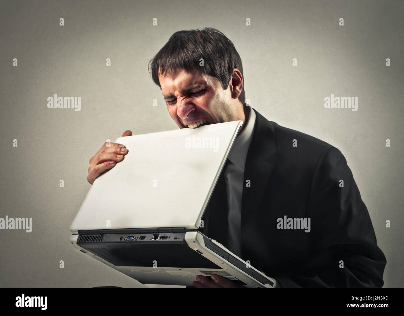 Businessman eating laptop Stock Photo - Alamy