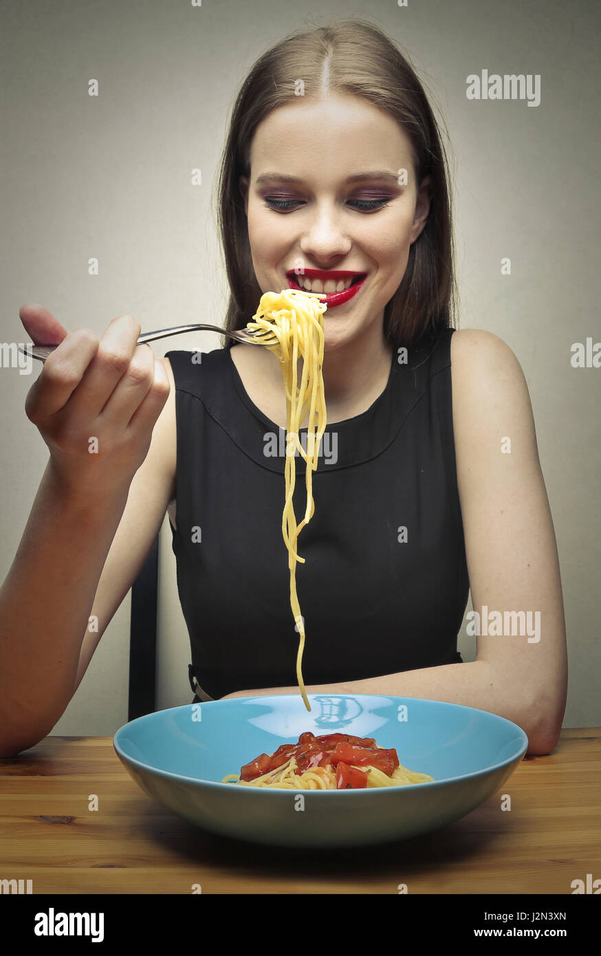 Young woman eating spagetti Stock Photo - Alamy
