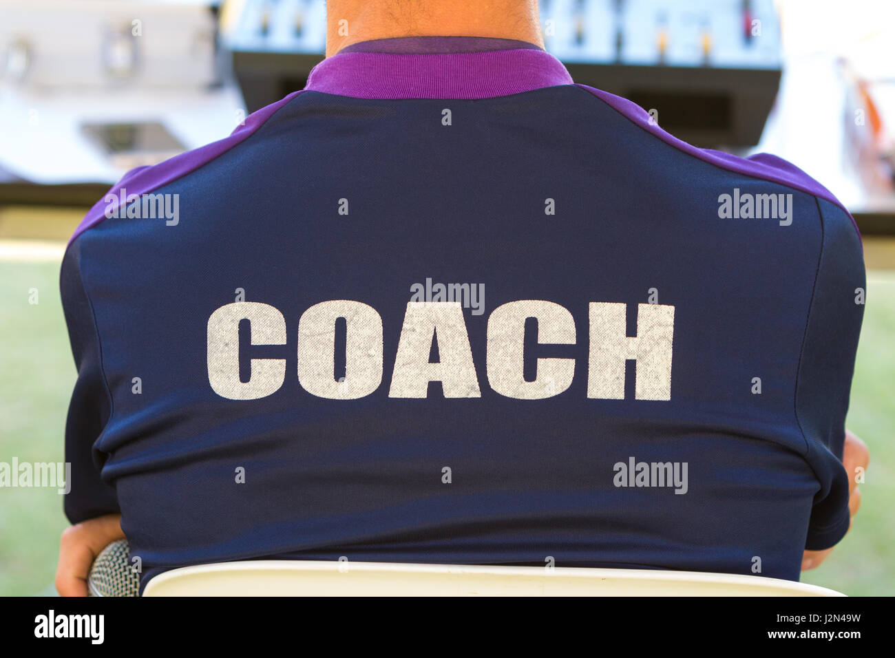 back of a coach's dark blue color shirt with the word Coach written on ...