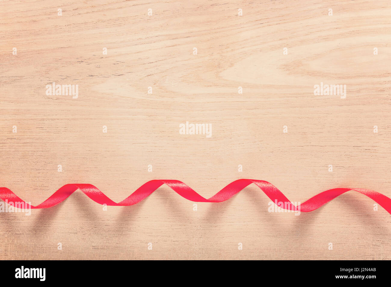 strip of red ribbon on wood background with vintage color tone with ...