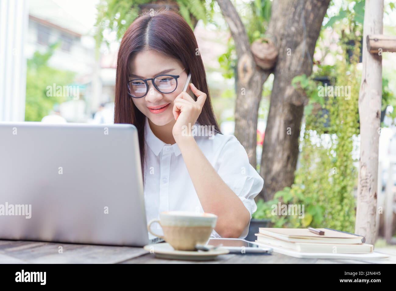 young happy asian woman using technology on her laptop computer and her ...