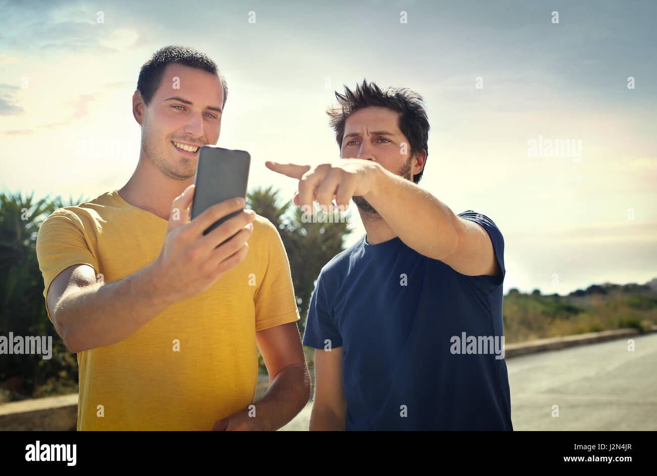 2 men looking at phone Stock Photo - Alamy