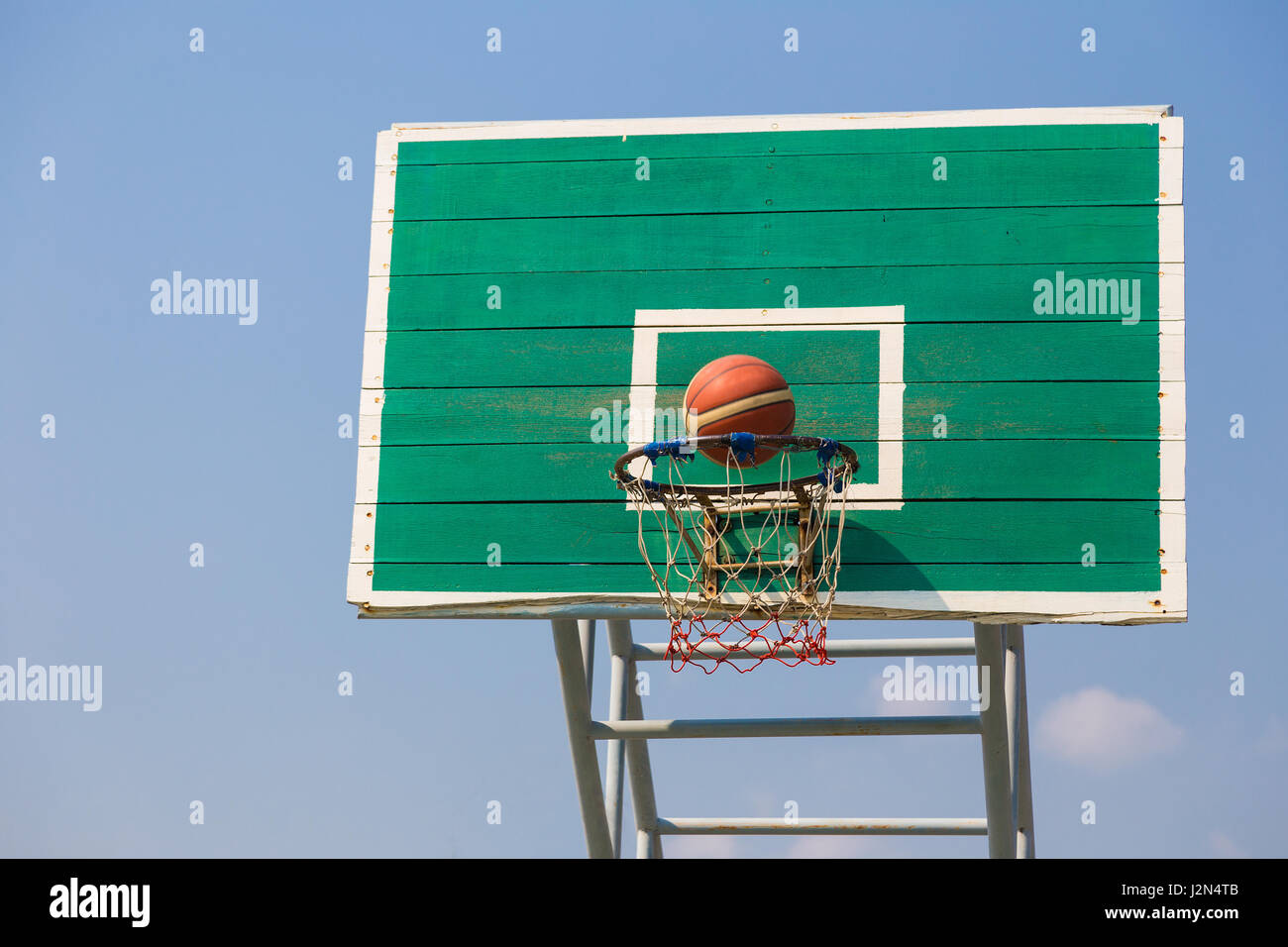 basketball fast moving into the basket at an outdoor field on a clear ...
