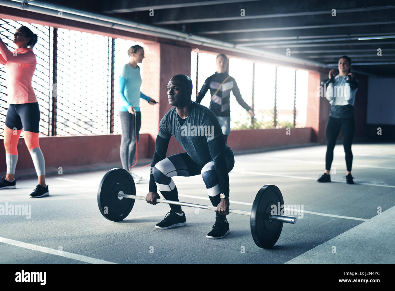 Muscular African American bodybuilder lifting weights crouching on a ...