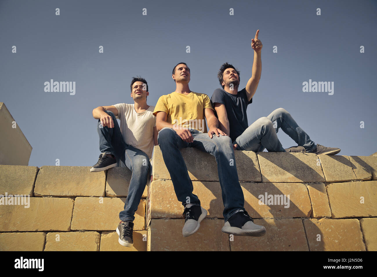3 men sitting outside Stock Photo - Alamy