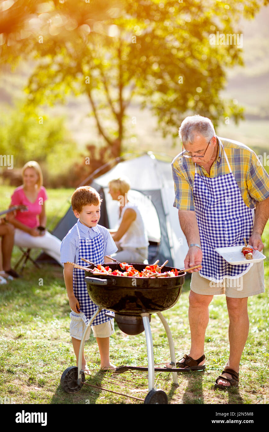 grandfather and grandson making barbecue on countryside Stock Photo - Alamy