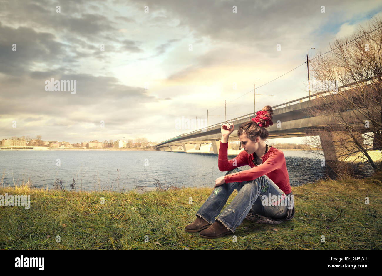 Poor woman sitting under bridge Stock Photo - Alamy