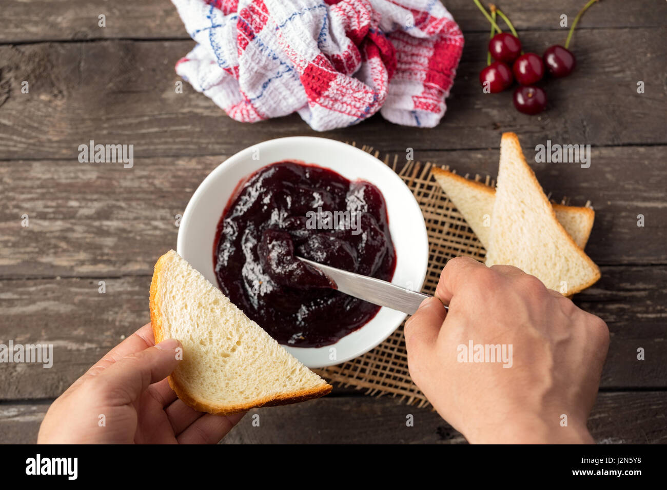 Man is preparing breakfast and spreading jam on slice toast Stock Photo ...