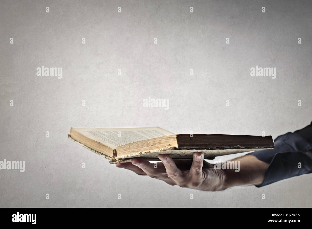 Opened book in someone's hand Stock Photo - Alamy