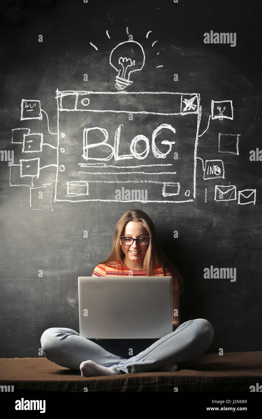 Young woman with laptop making a blog Stock Photo - Alamy