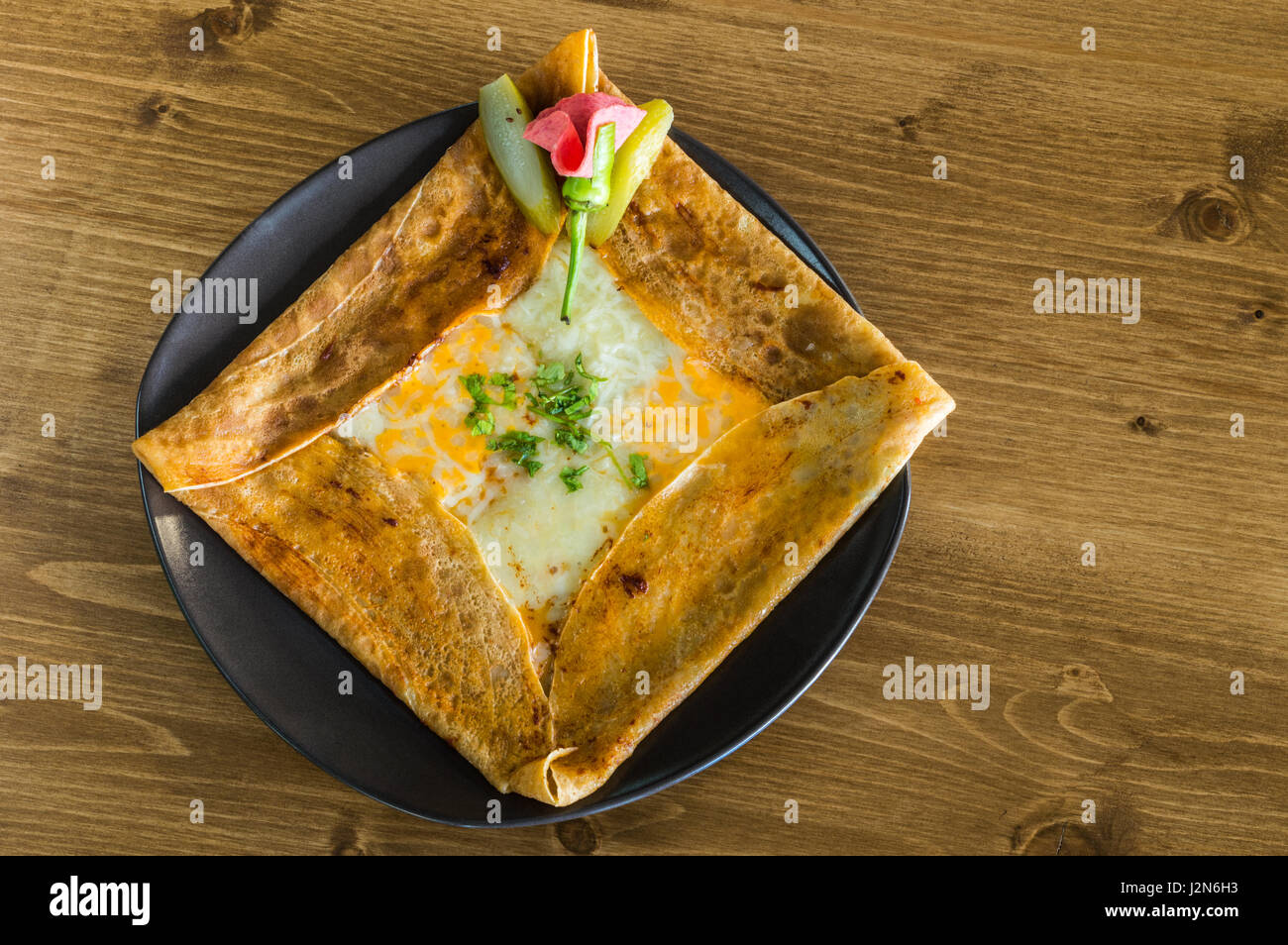Top view of delicious crepe with cheddar cheese served on a grey plate ...