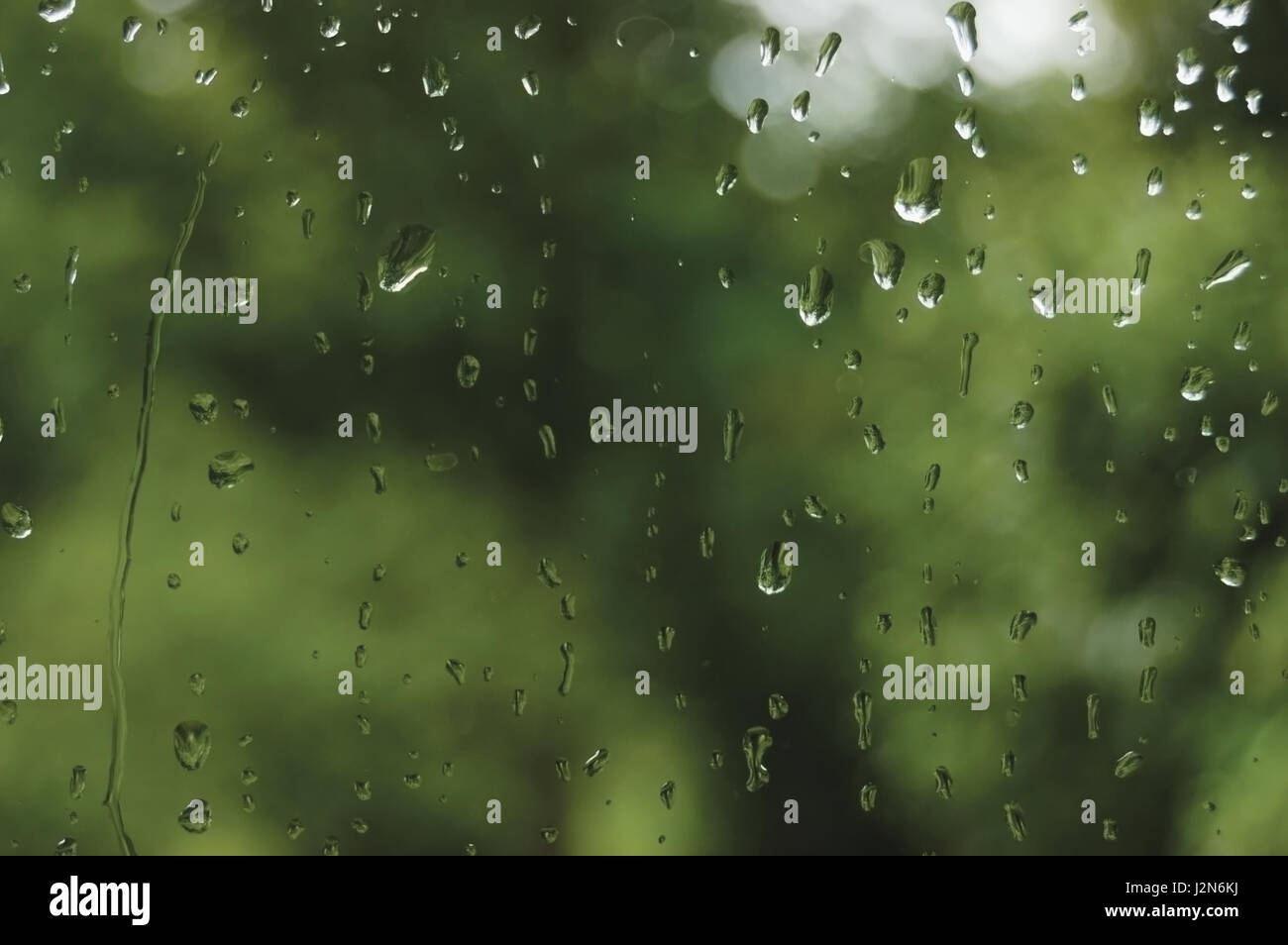 Rainy summer day, raindrops on wet window glass, horizontal bright ...