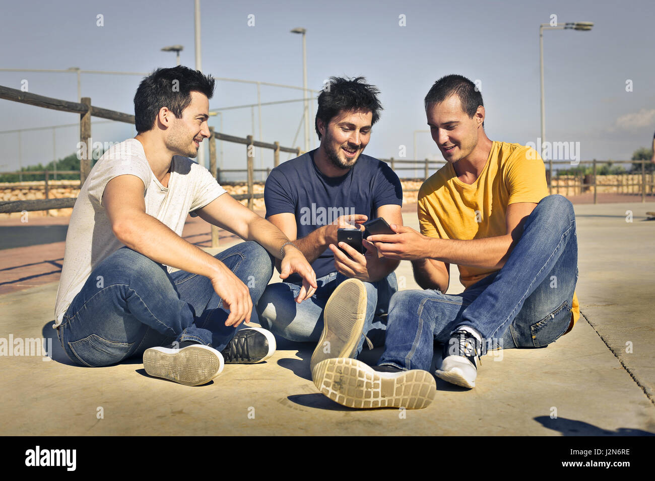 3 man friends sitting outside Stock Photo - Alamy