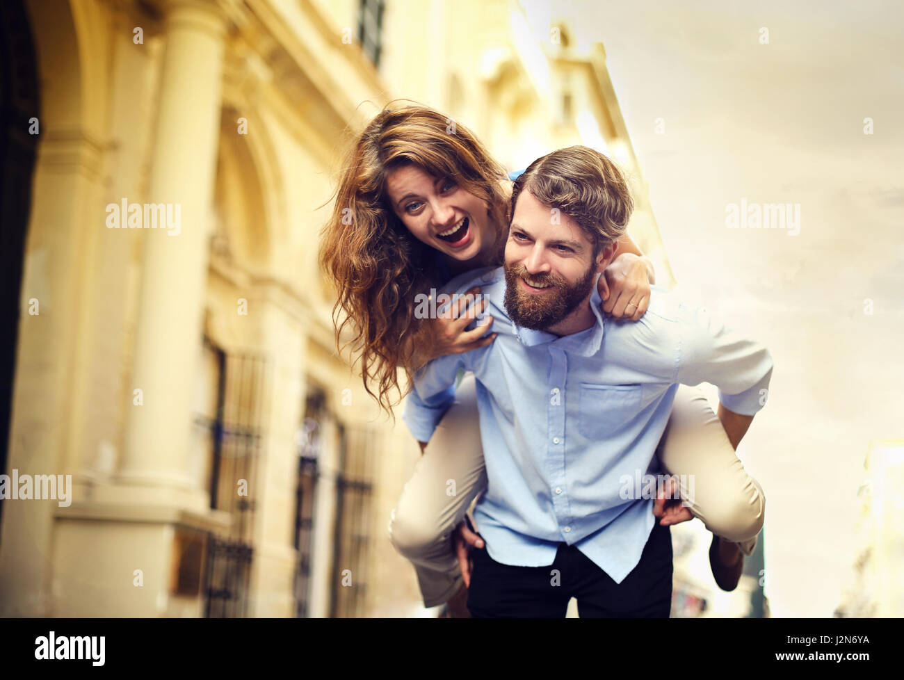 Man giving woman a piggy back Stock Photo - Alamy