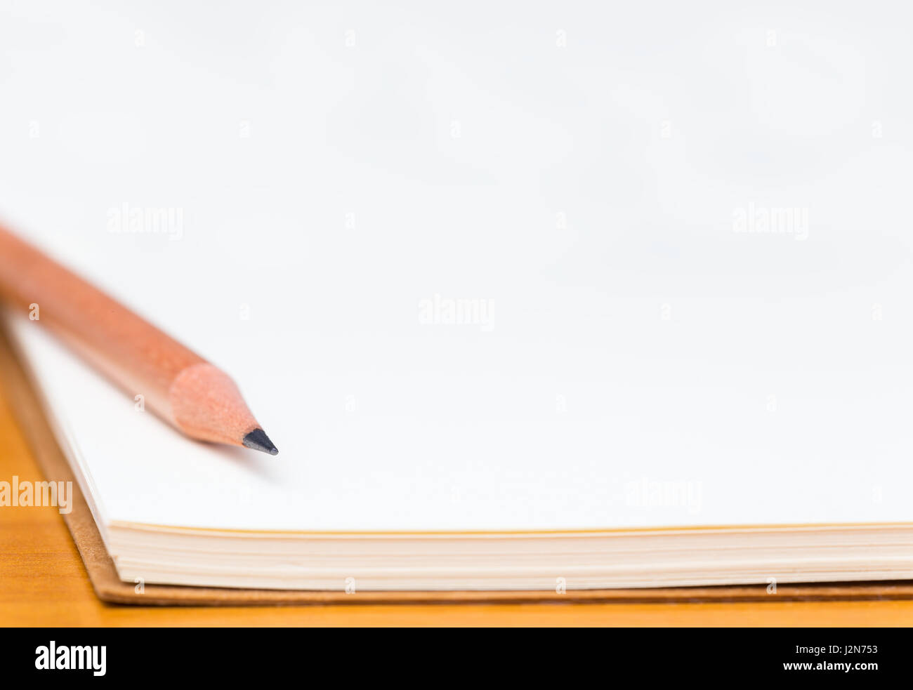 Single pencil on blank white notebook with room for copy space ...