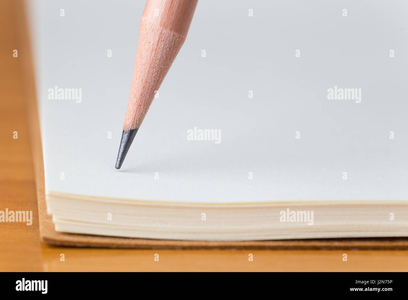 Pencil pointing on blank white notebook, selective focus on pencil ...