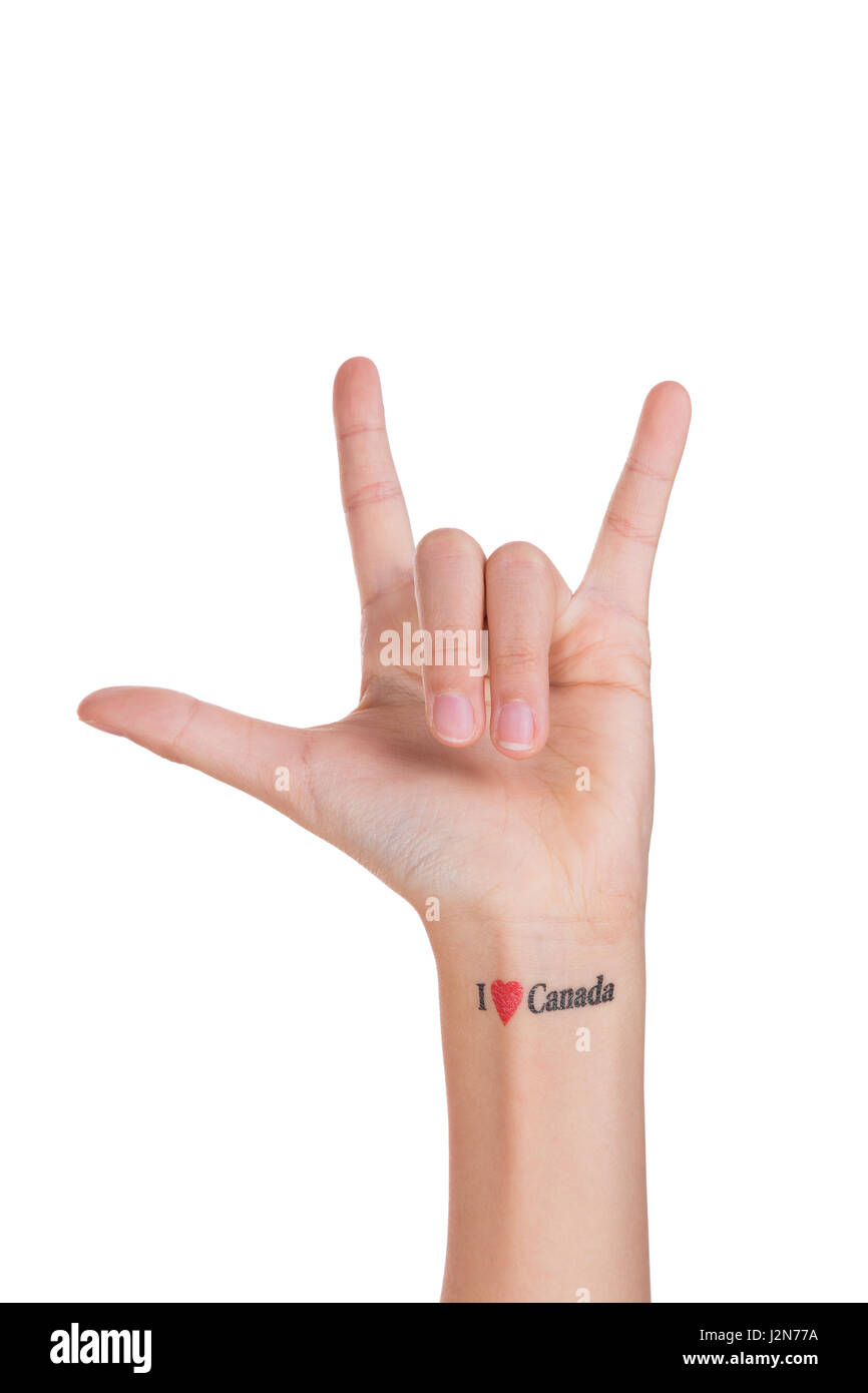 Hand with fingers forming love sign with I love Canada tatton on the ...