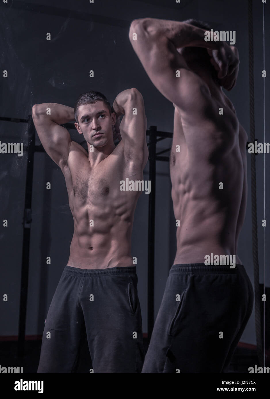 bodybuilder posing, looking at himself, double mirror image, muscular ...