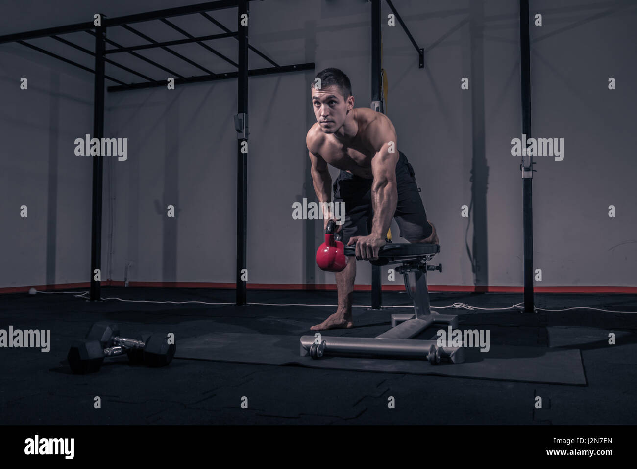 one young adult man, bodybuilder, flat bench, Kettle Bell exercise ...