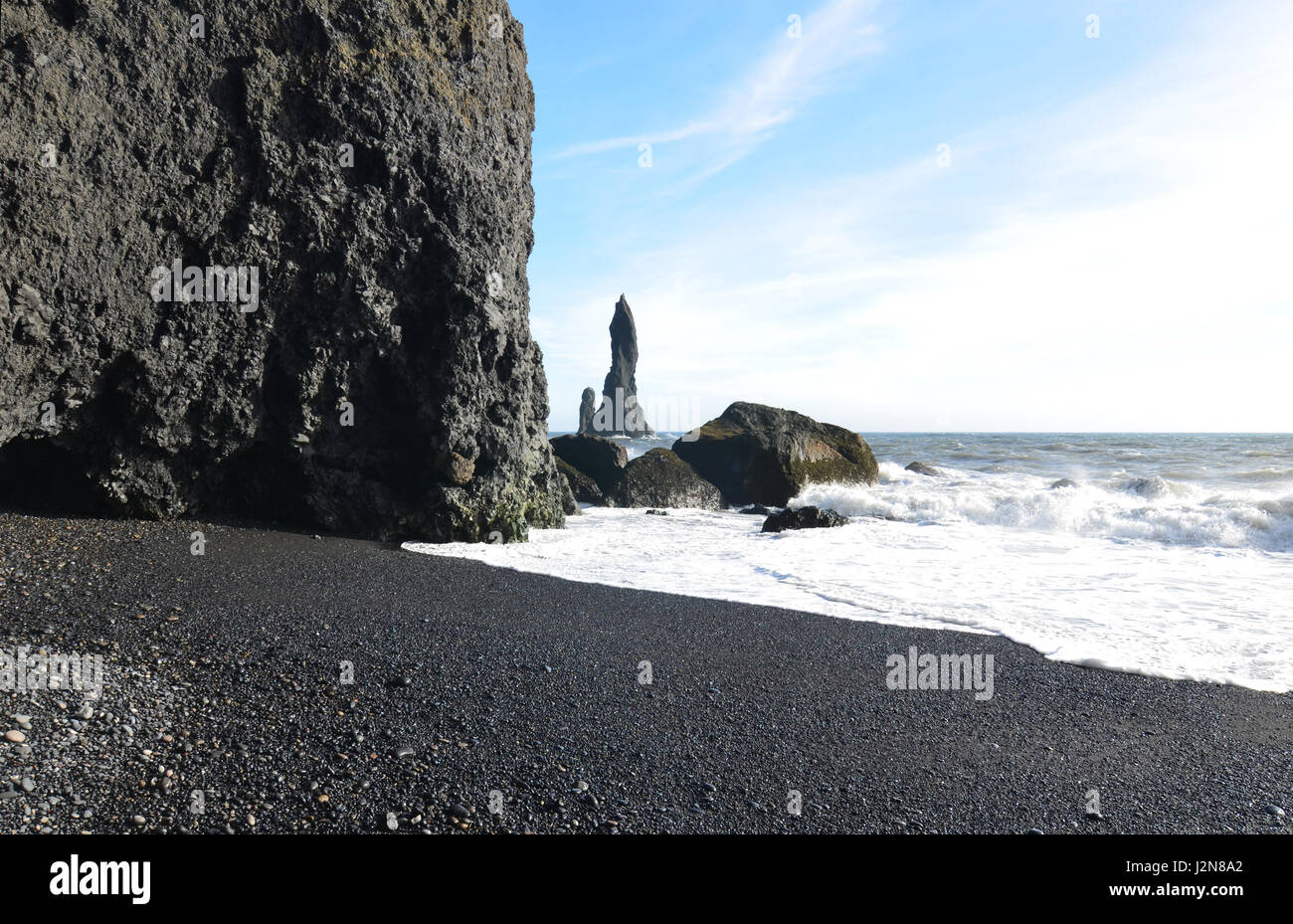 Sea stack rock formation off the coast of a black sand beach in Vik ...