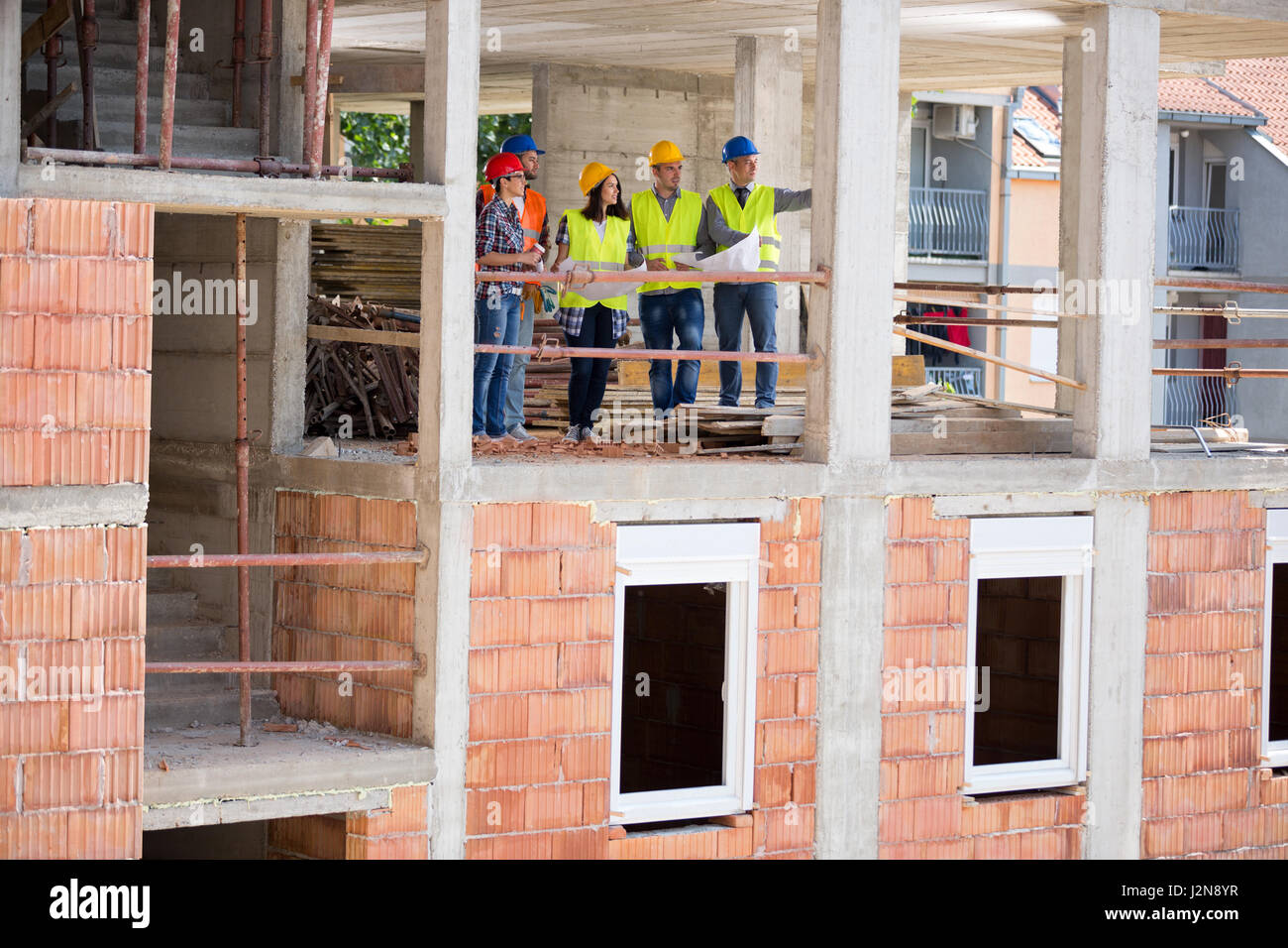 Side view of construction in progress with group of architects ...